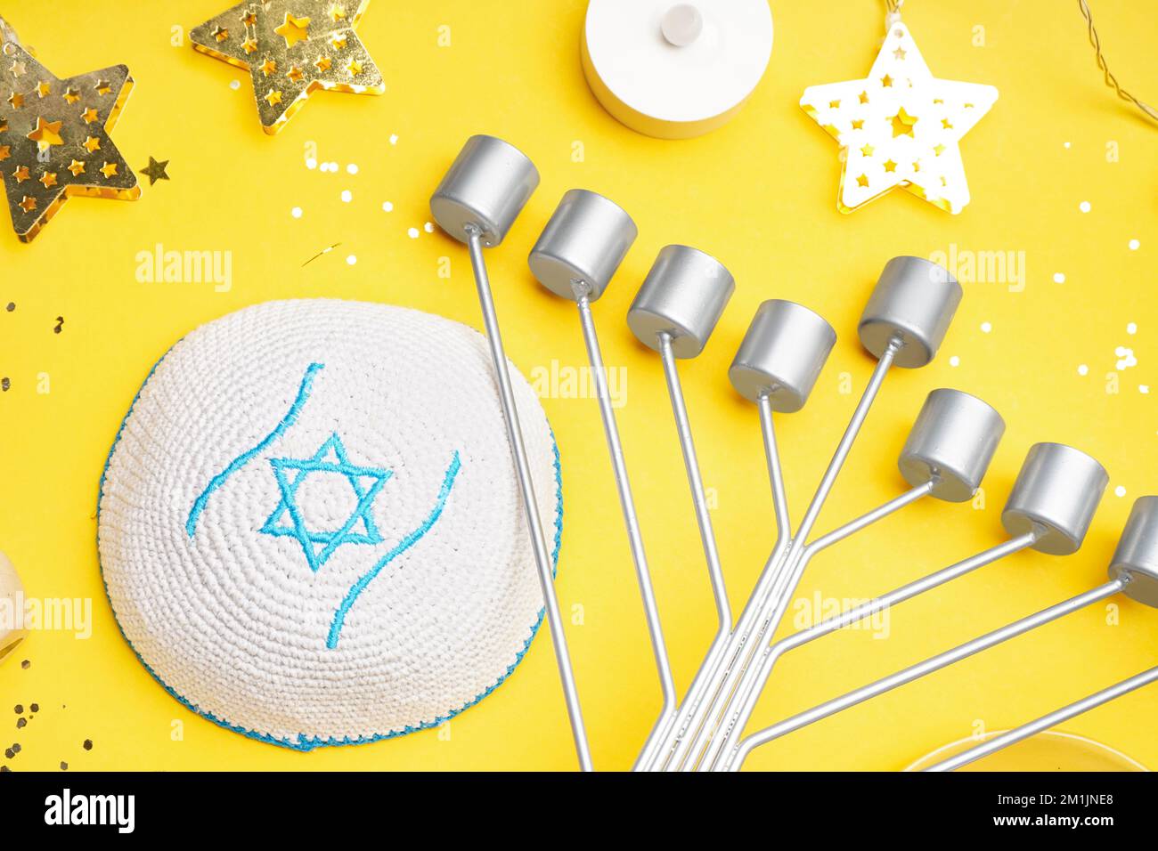 Menorah with Jewish hat for Hannukah celebration on yellow background ...