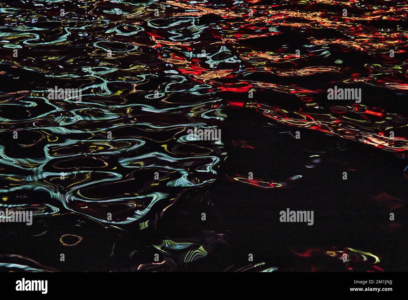 Blue and red lights reflecting off waves of water in river Stock Photo ...