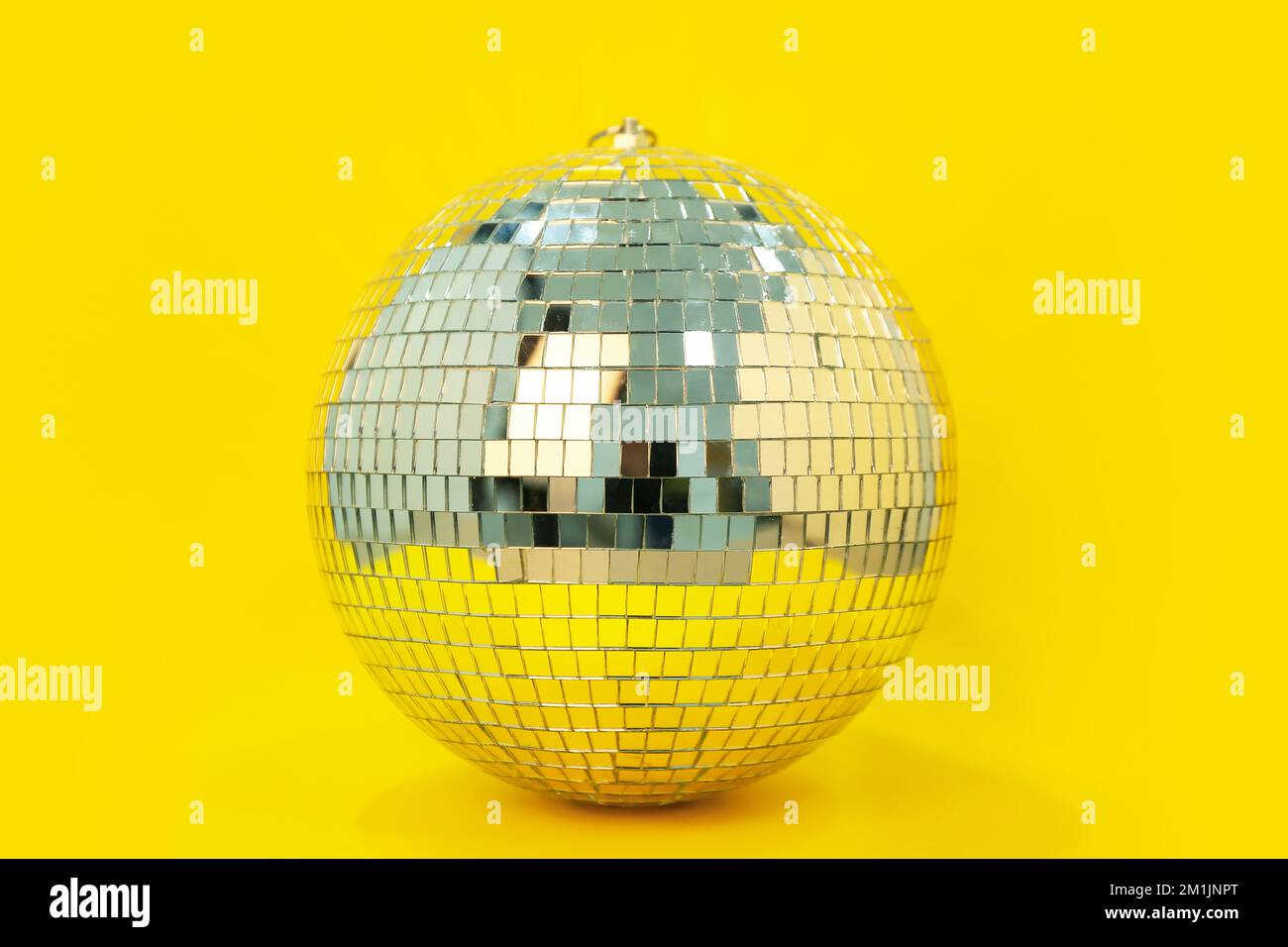 Disco ball on yellow background Stock Photo - Alamy