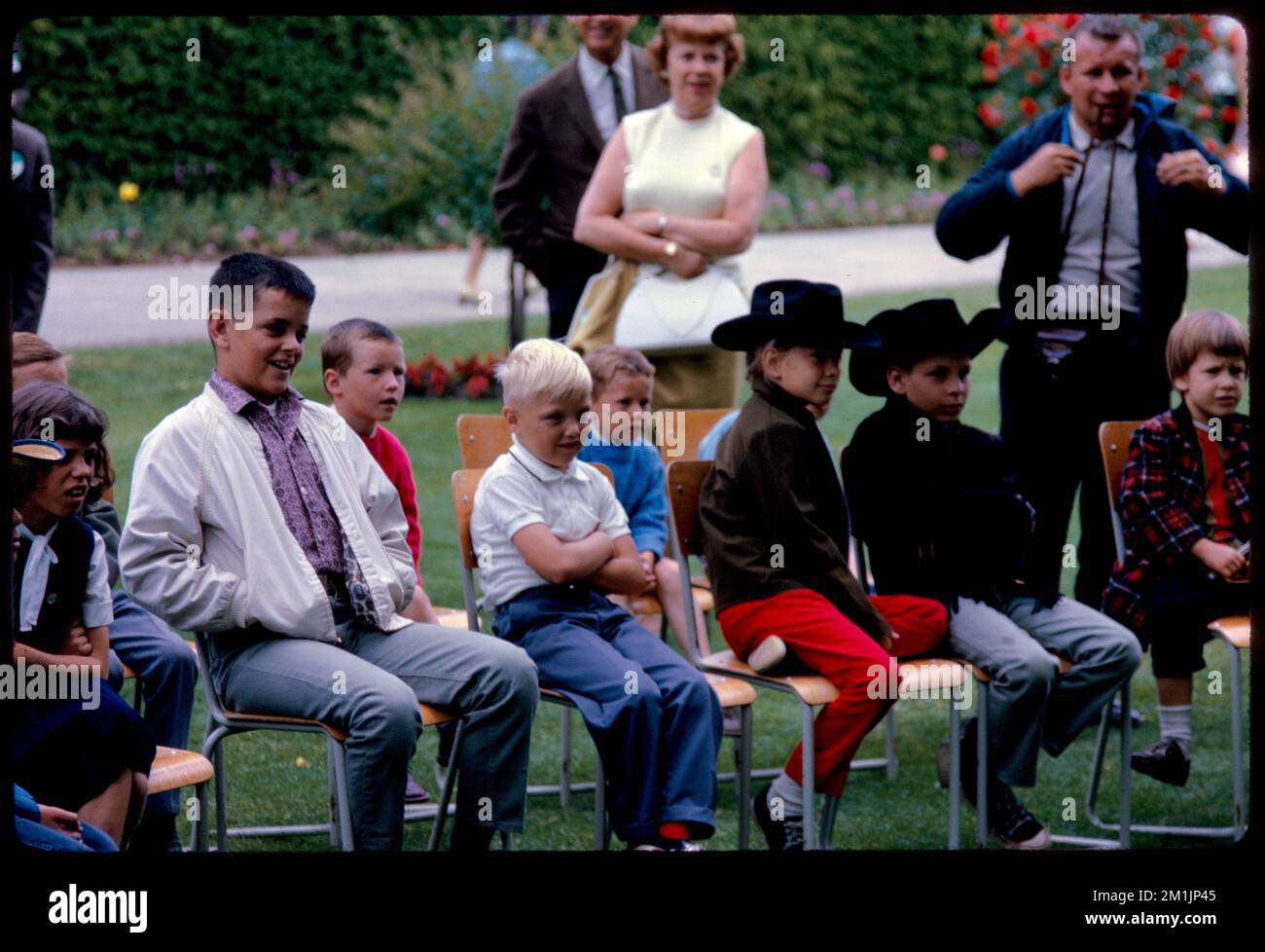 Adults standing behind row of children watching puppet show, British ...