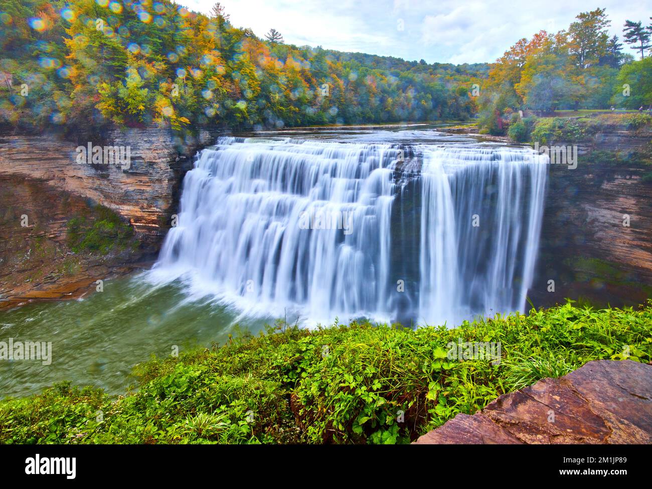 Stunning waterfall pouring over cliffs with drops splashing on lens and ...