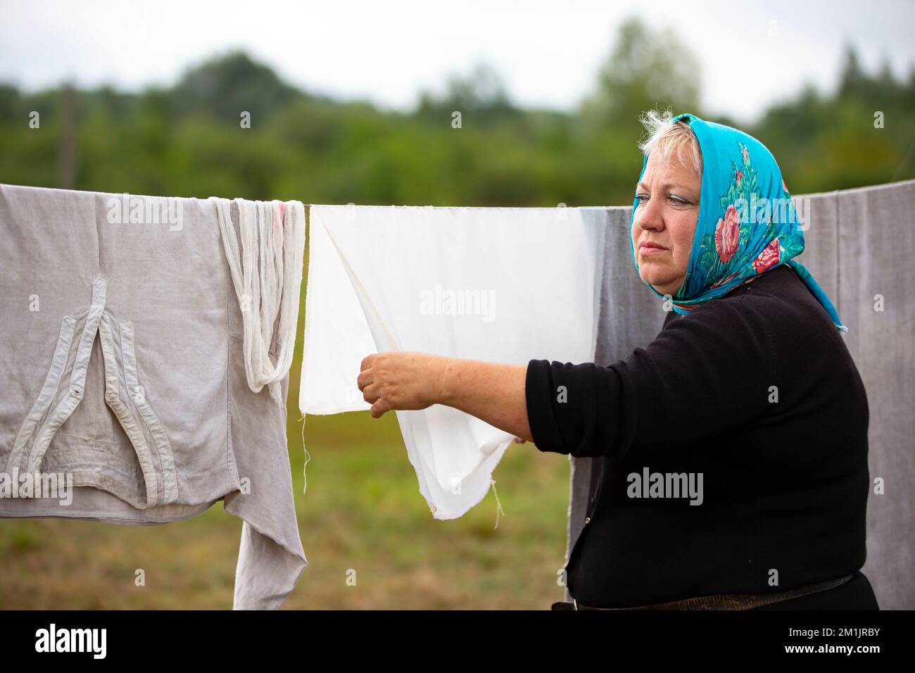 Refugee camp.A woman in a refugee camp hangs clothes to dry outside ...