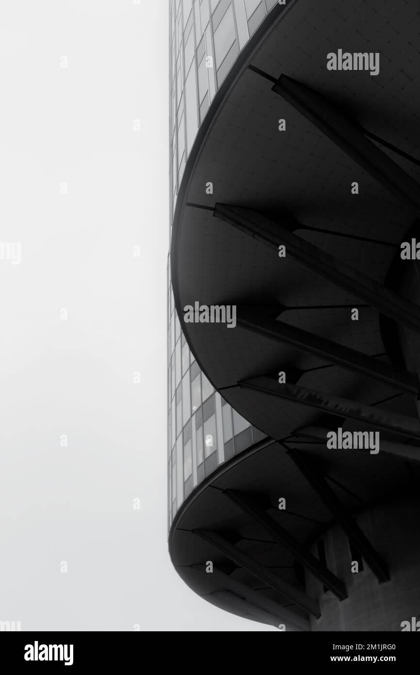 A vertical shot of a glass-walled office silo building in the city of ...