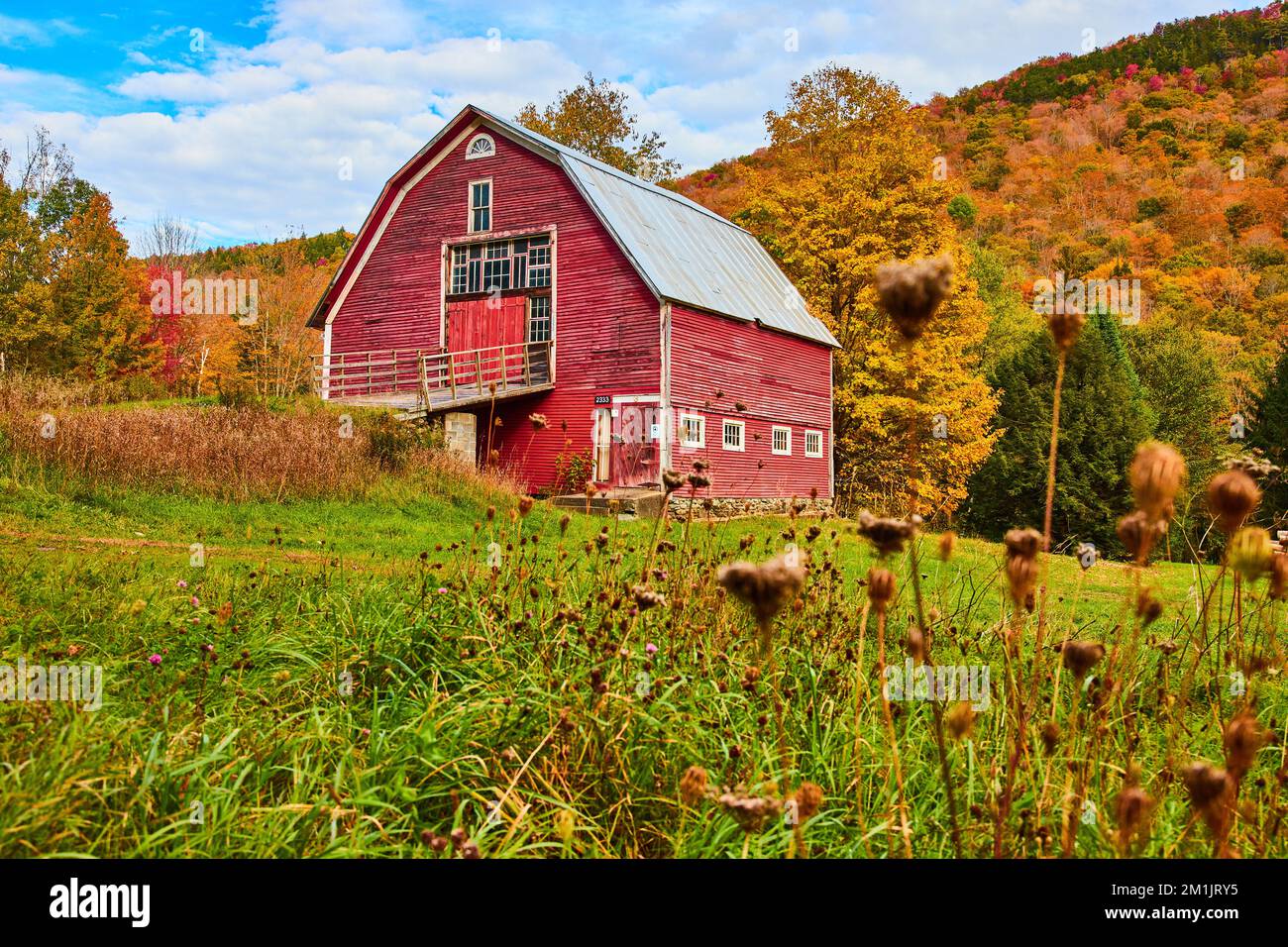 Beautiful red country barn in grassy fields with hills of colorful ...