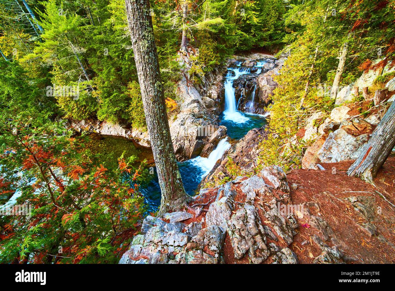 On trail cliff edge overlooking beautiful blue waterfalls pouring into ...