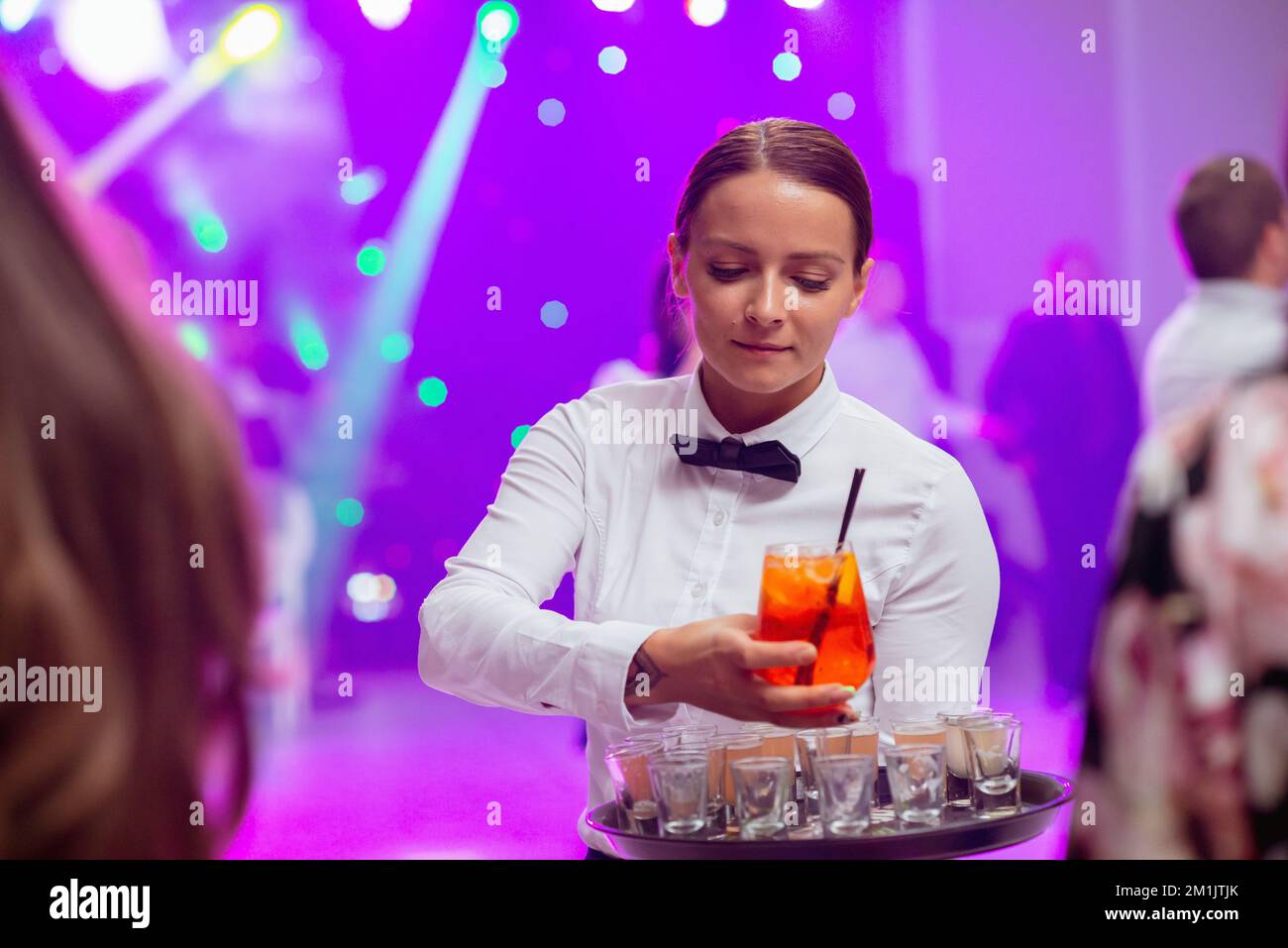 A preety young waitress serving drinks cocktails during a Party Stock ...