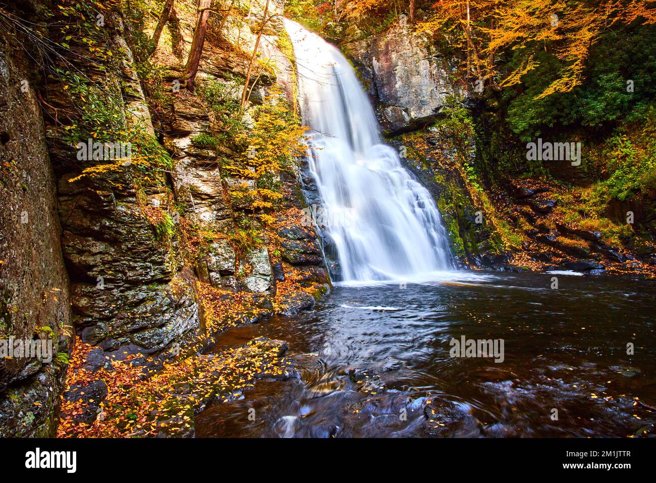 Stunning cliffs covered in golden leaves along river in fall with ...