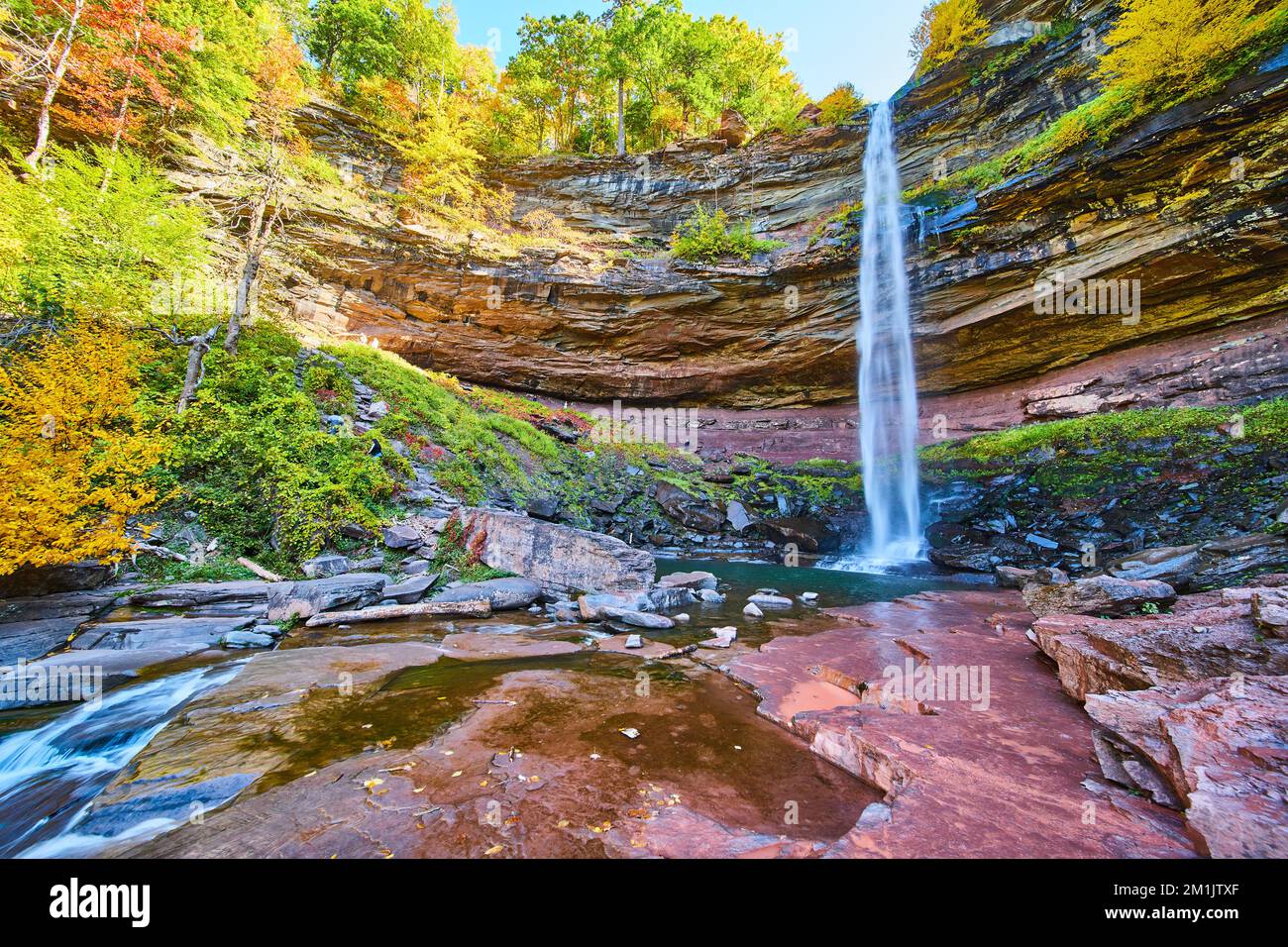 Cliffs of many layers with large waterfall crashing down below into ...