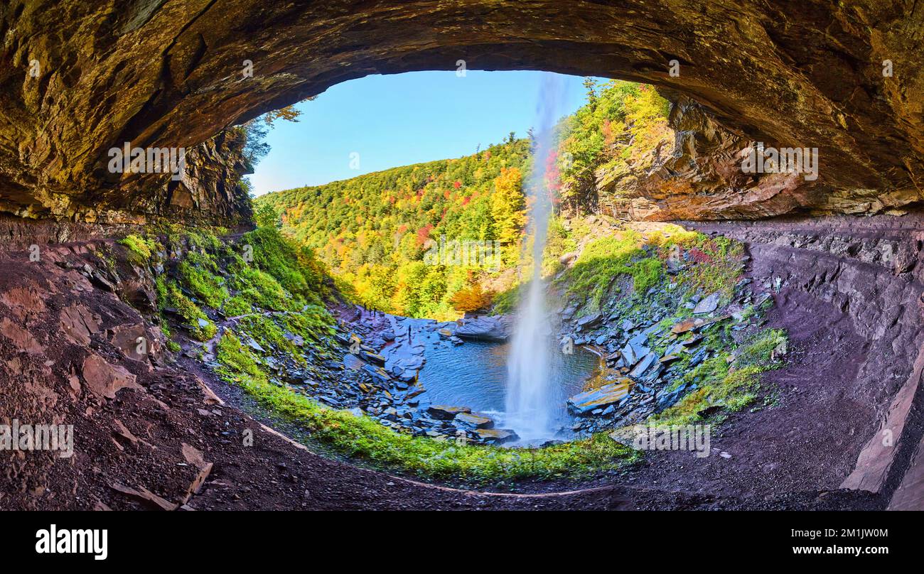 Wide angle in cave space behind waterfall over cliff edge with fall ...