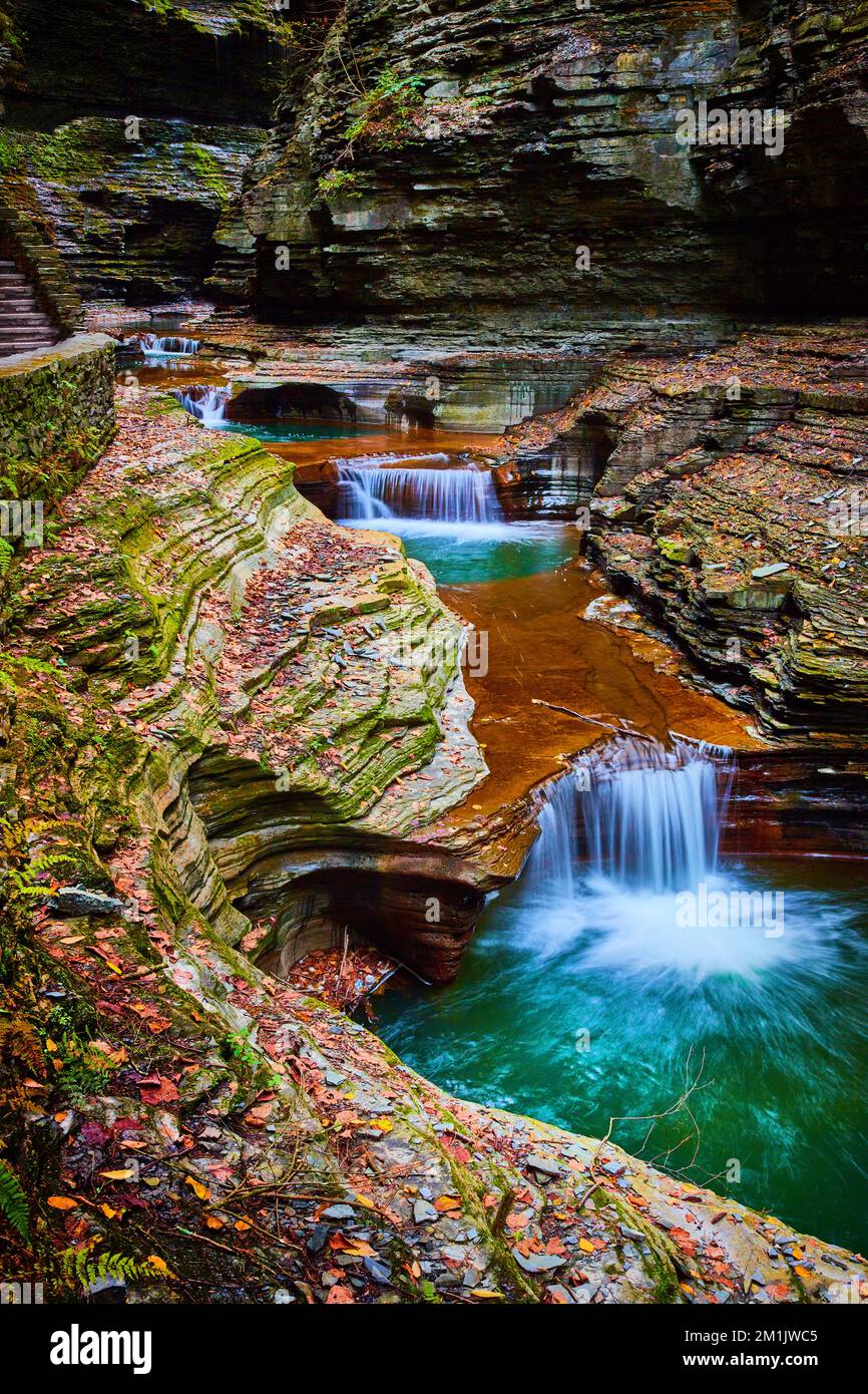 River with cascading buckets of blue water and waterfalls through gorge ...