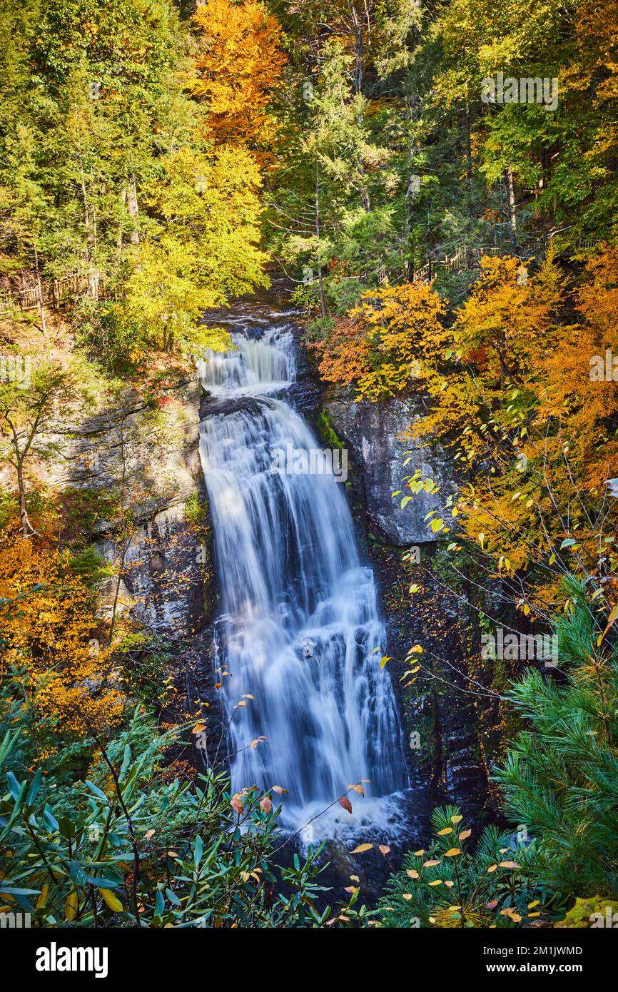 Large waterfall over cliffs surrounded by fall foliage trees Stock ...