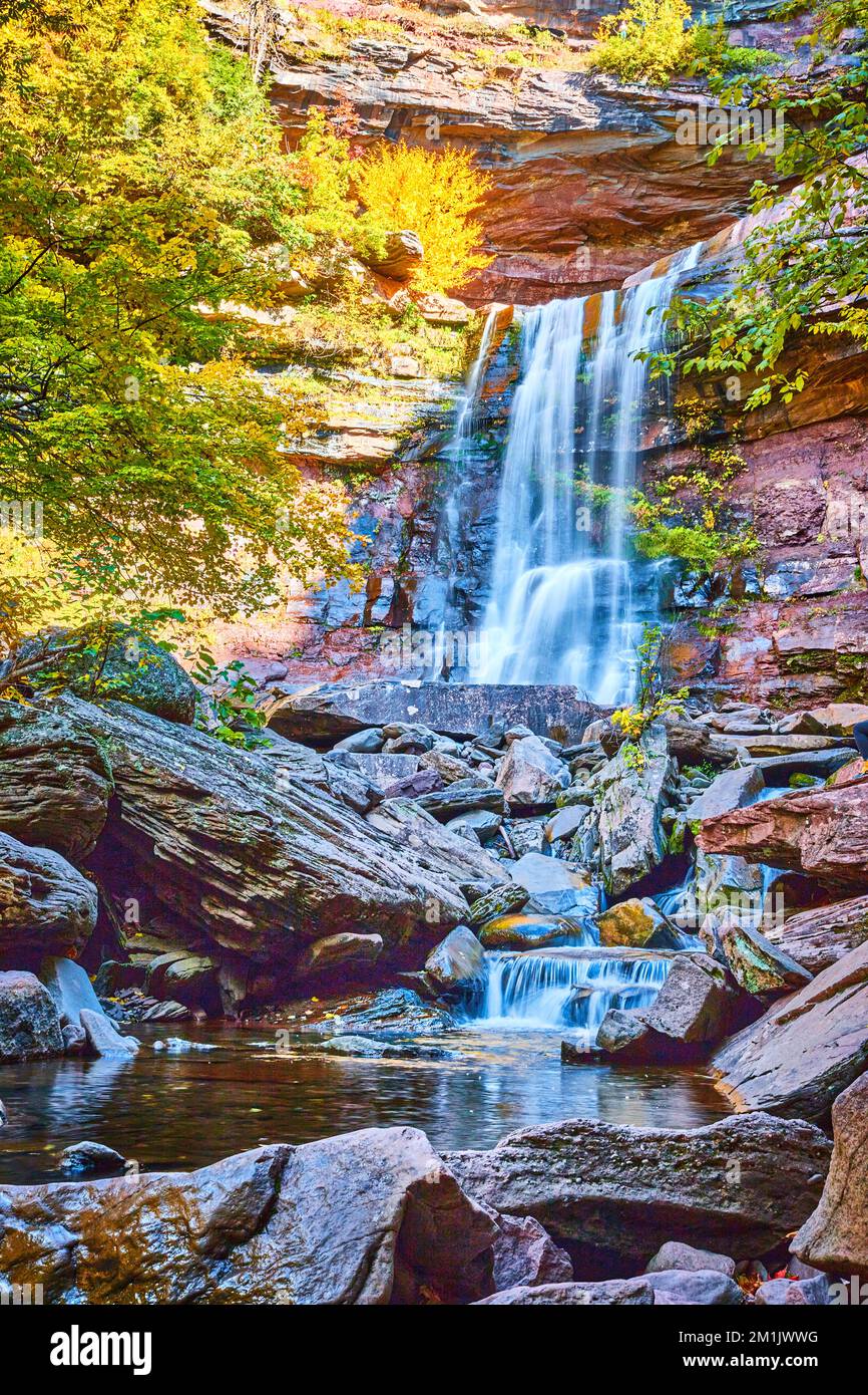 Looking up towards layers of cascading waterfalls over rocky cliffs ...