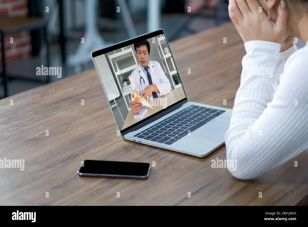 Back view of woman sit at desk at home have webcam conference on laptop ...