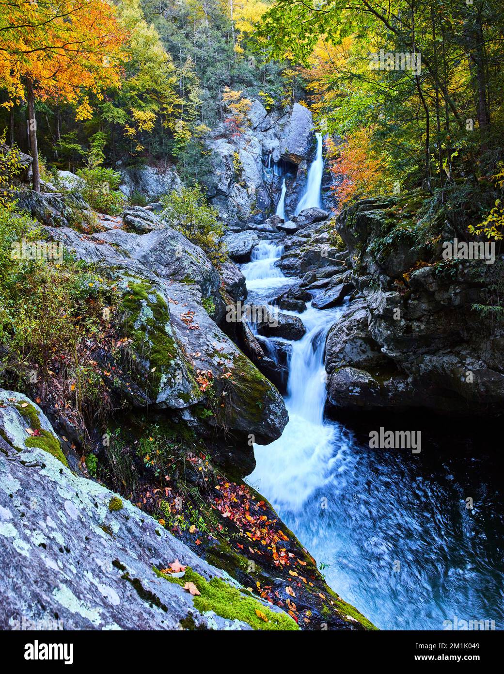 Fall foliage surrounds waterfalls through gorge in stunning fall forest ...