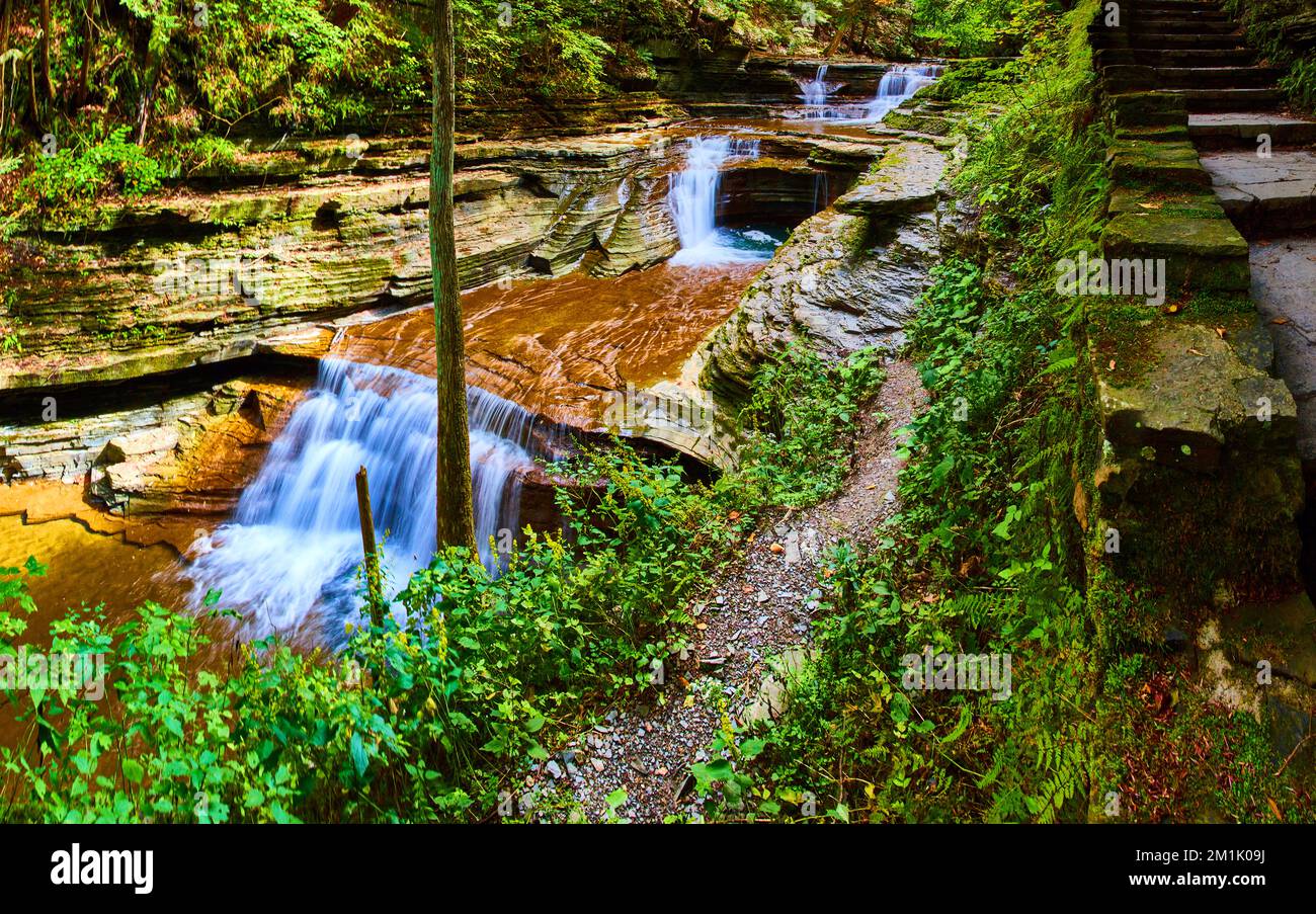 Simple path and stone steps along river with cascading tiers of ...