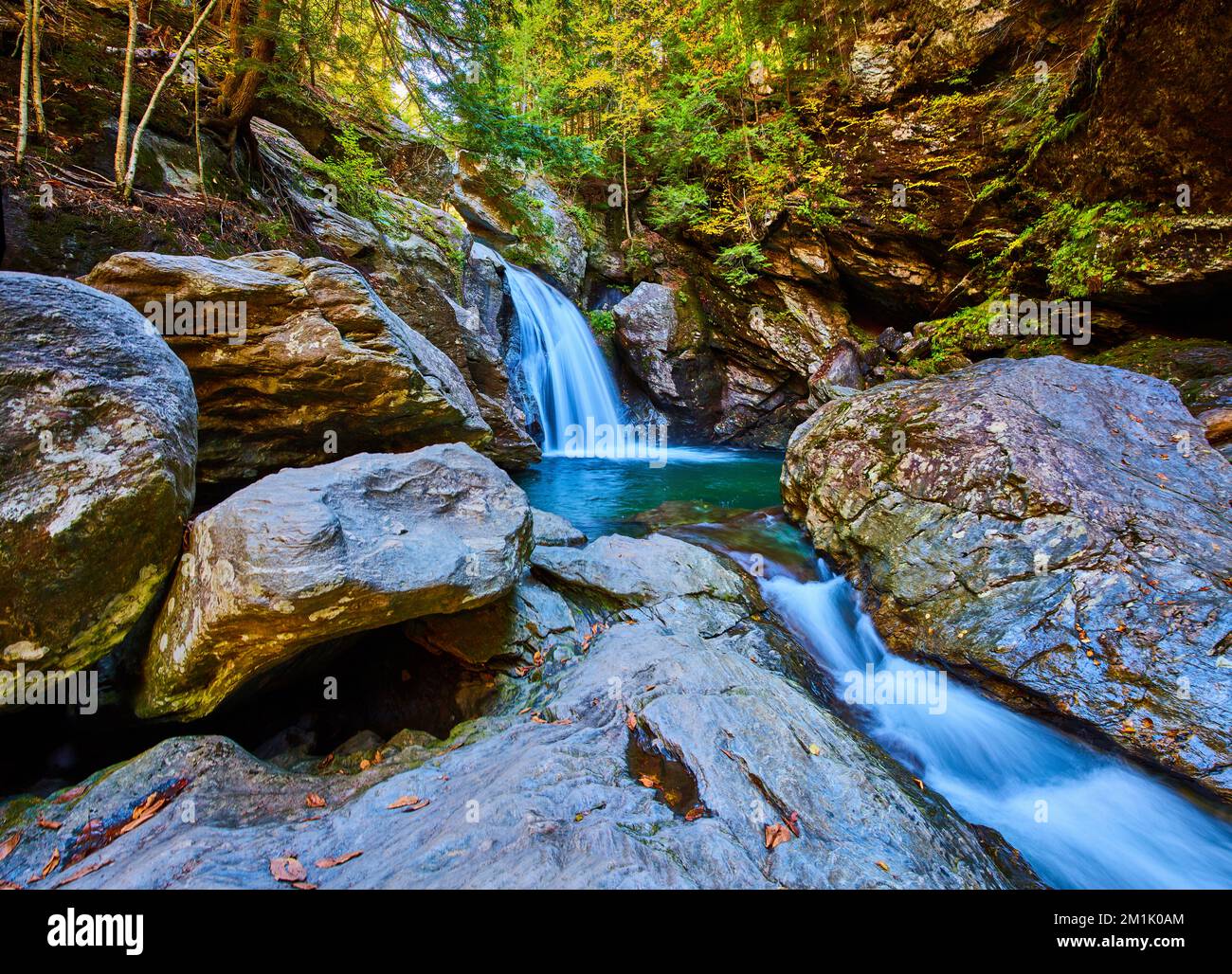 Stunning waterfall into pool of water leading to rapids through rocks ...