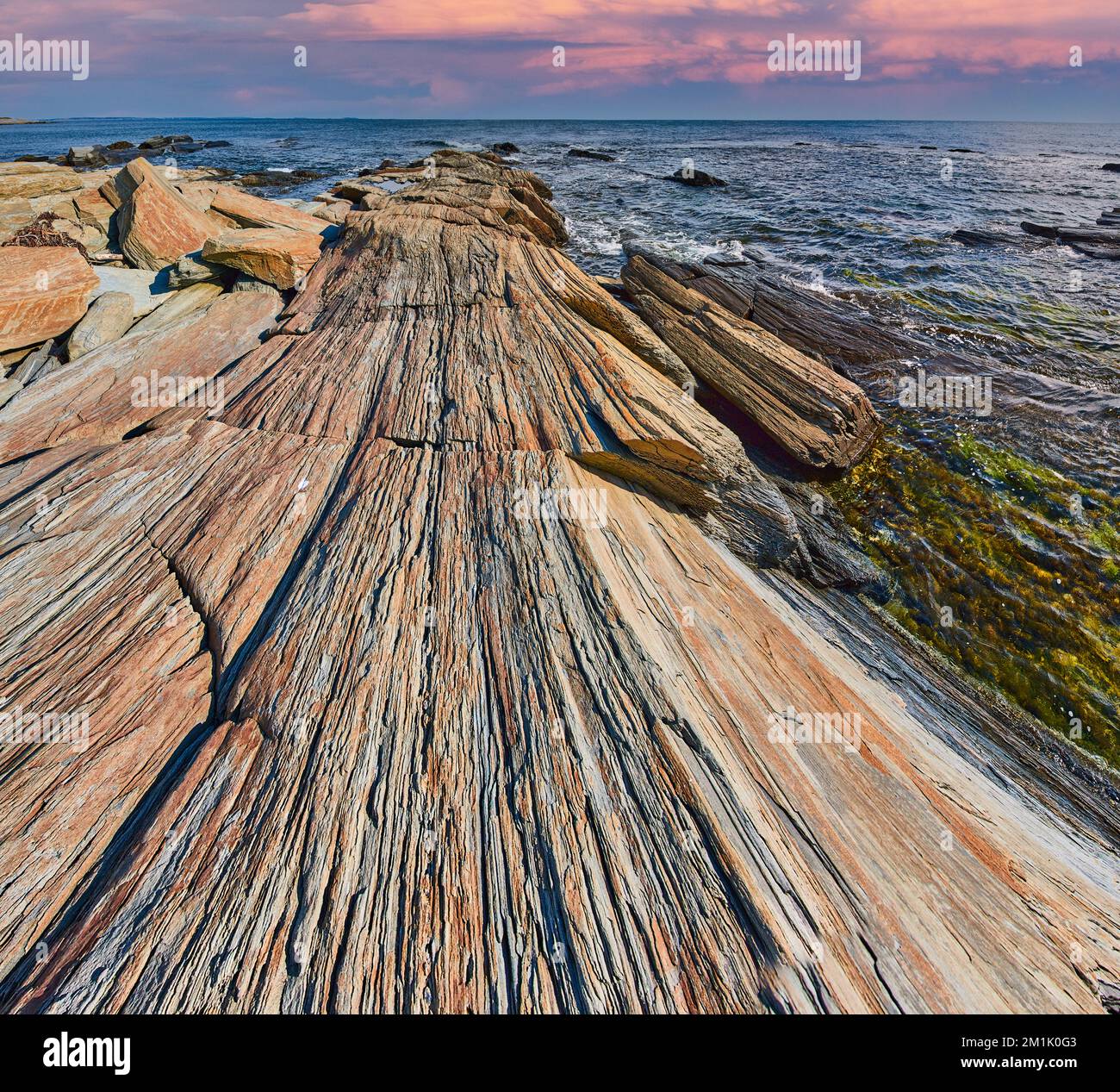 Stunning rocky sheet layers forming on ocean coast in Maine with golden ...
