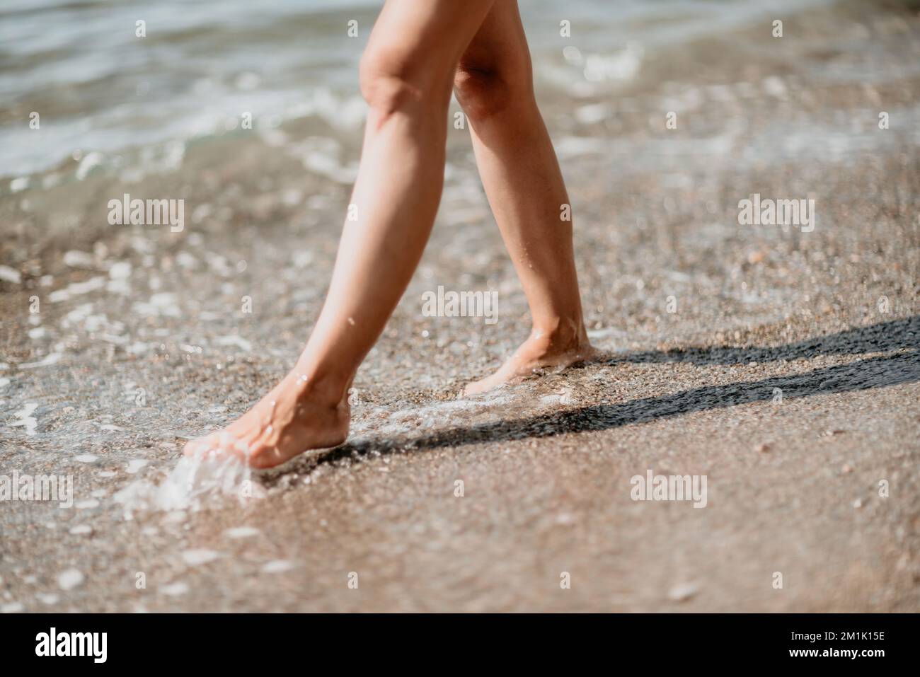 A woman walks along the beach, legs close-up. Barefoot woman sta Stock ...