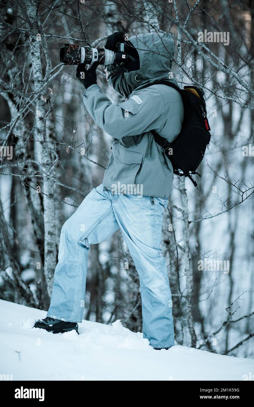 Man in snowy forest with camera and backpack Stock Photo - Alamy