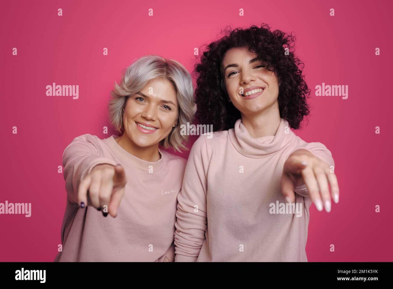 Image of happy two women friends having fun isolated over pink ...