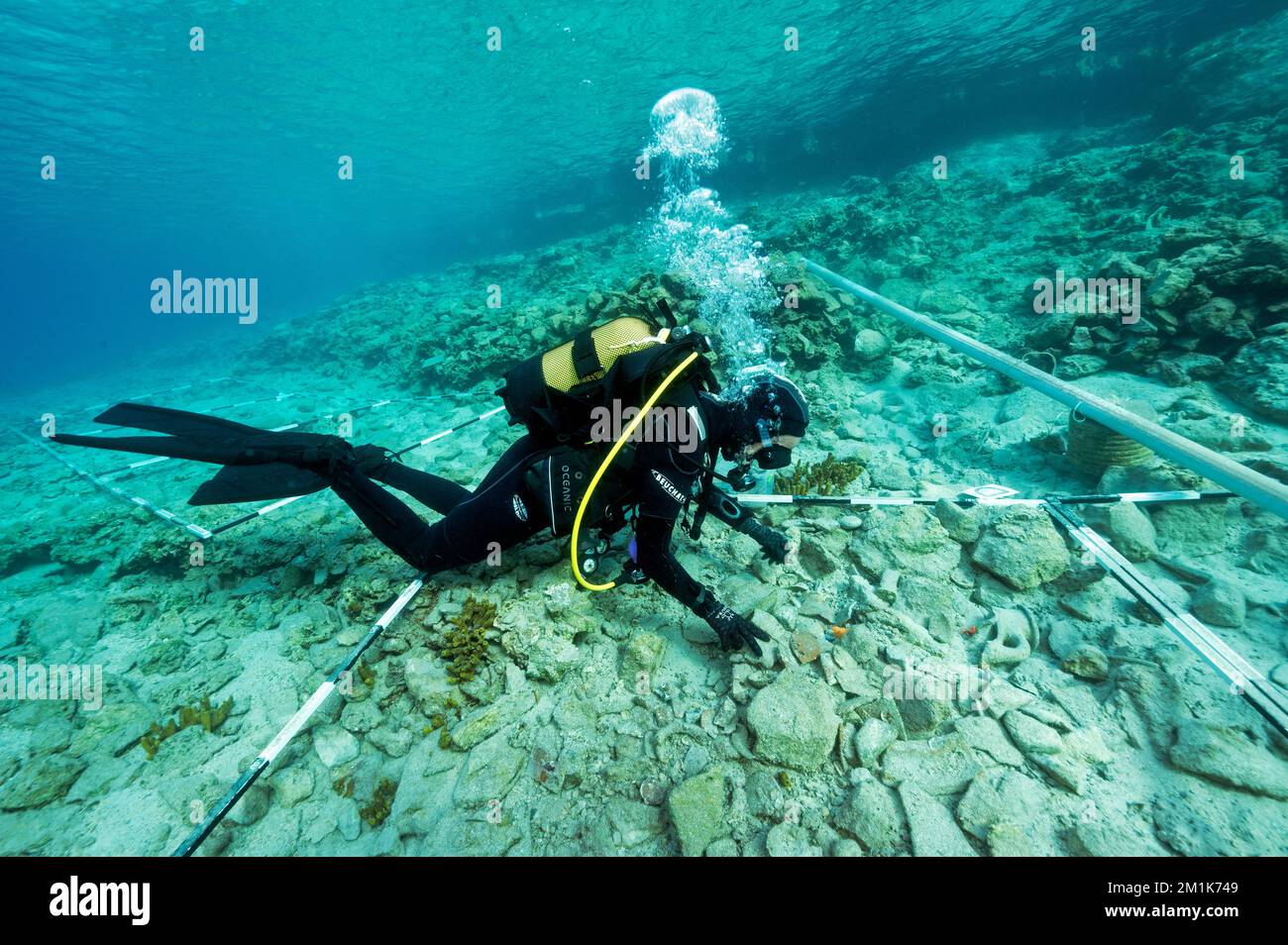 An underwater archaeologist airlifting on the ancient bronze age harbor ...