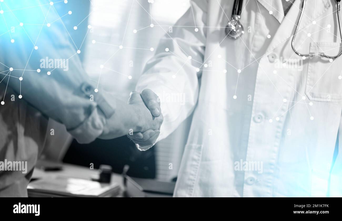 Doctor shaking hands with his female patient; light effect Stock Photo ...