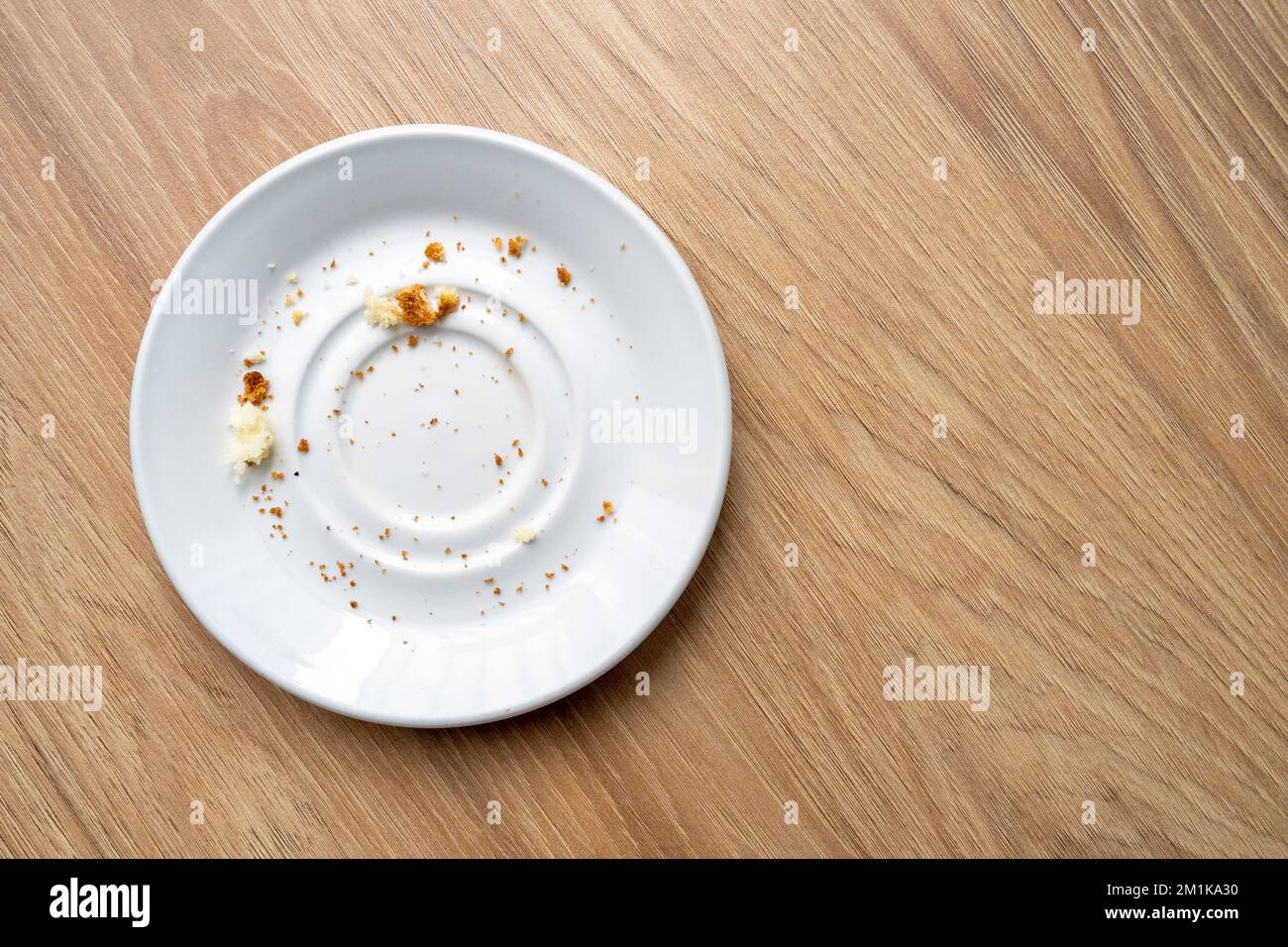 Brown cake crumbs on round white plate, top view Stock Photo - Alamy