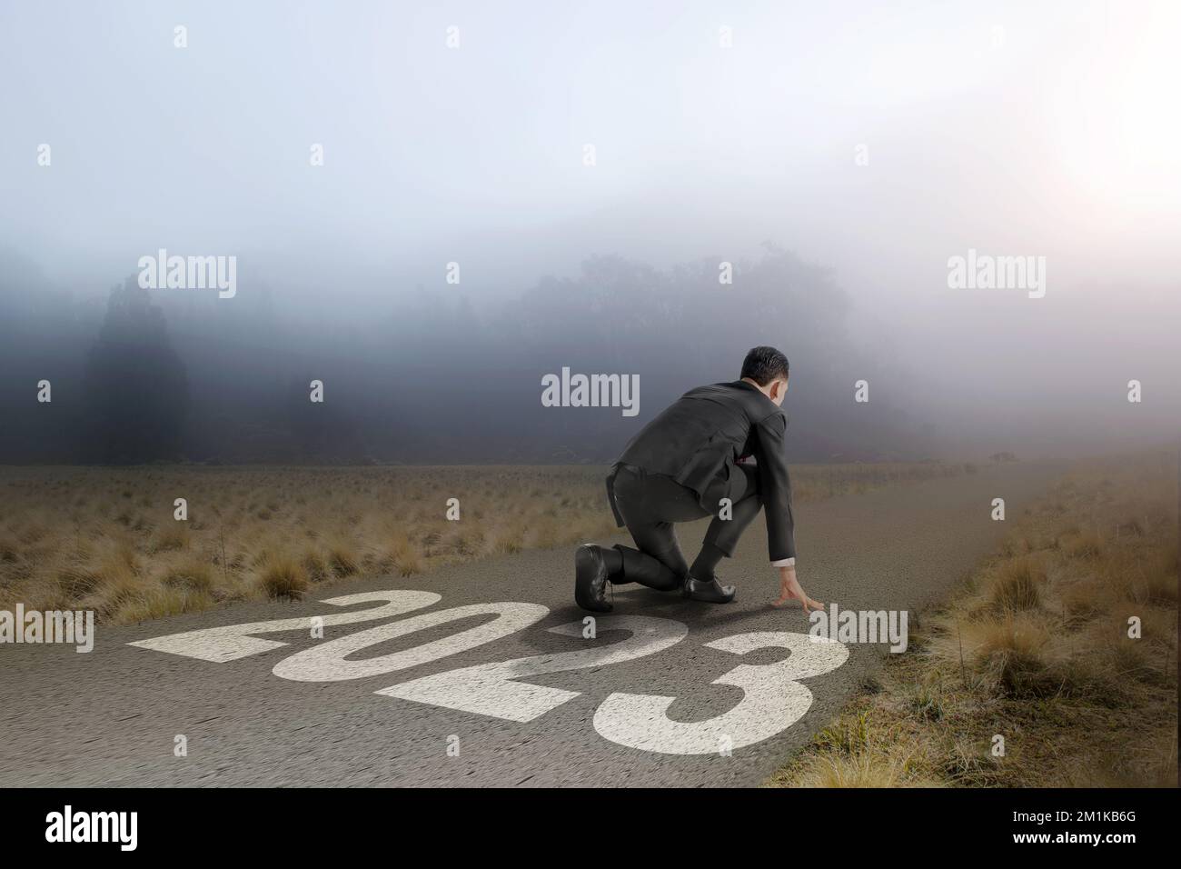 Rear view of Asian businessman in start position ready to run on the ...