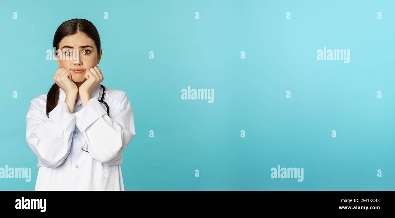 Scared and worried woman doctor in white coat, looking anxious and ...