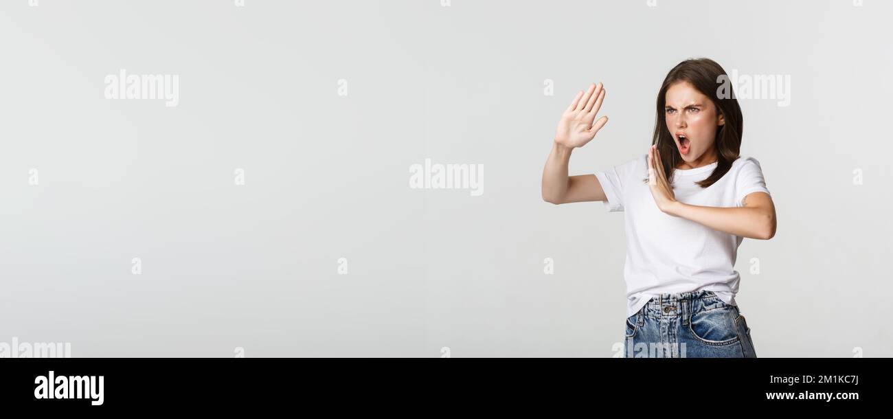 Sassy young woman standing in fighting pose to protect herself from ...