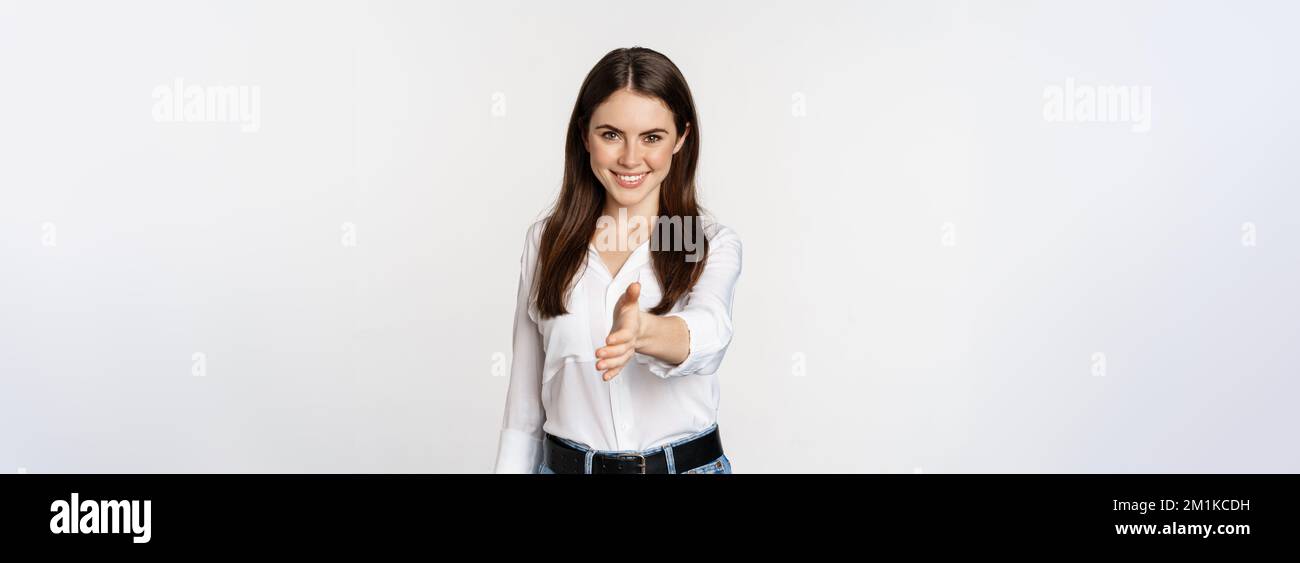 Smiling, friendly corporate woman extending arm for handshake, shaking ...