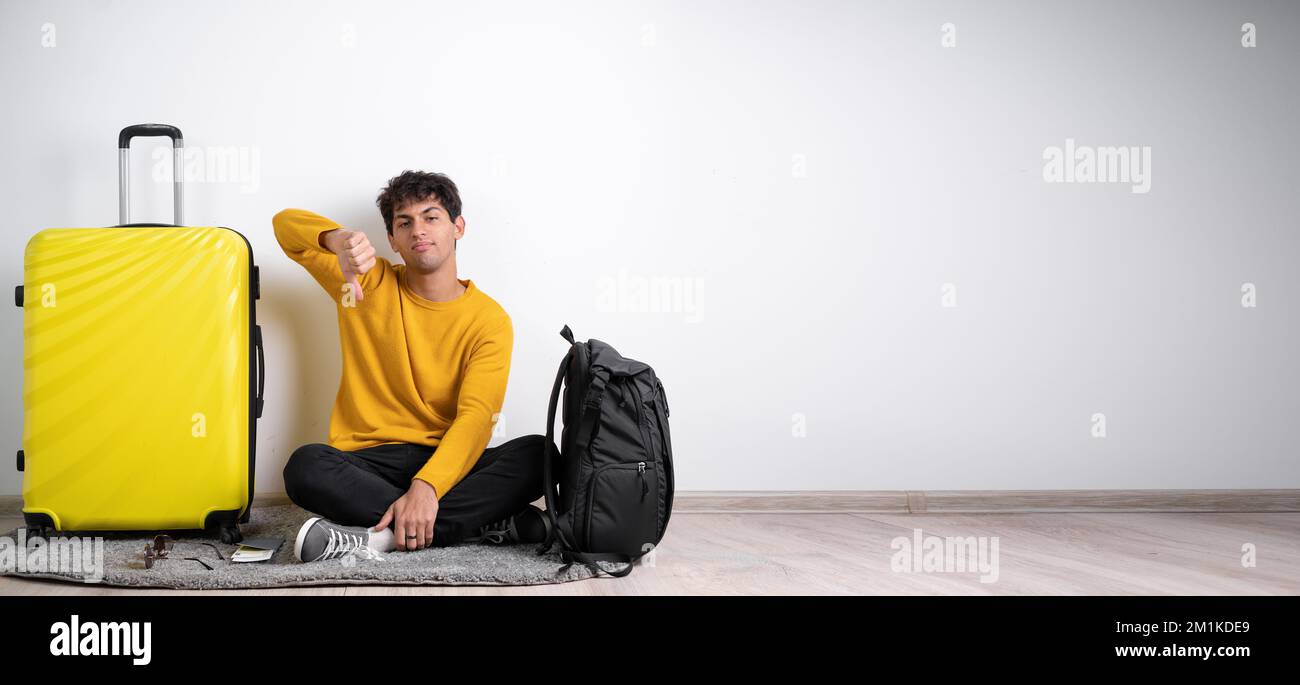 Young arab traveler with suitcase showing thumb down bad gesture bad ...