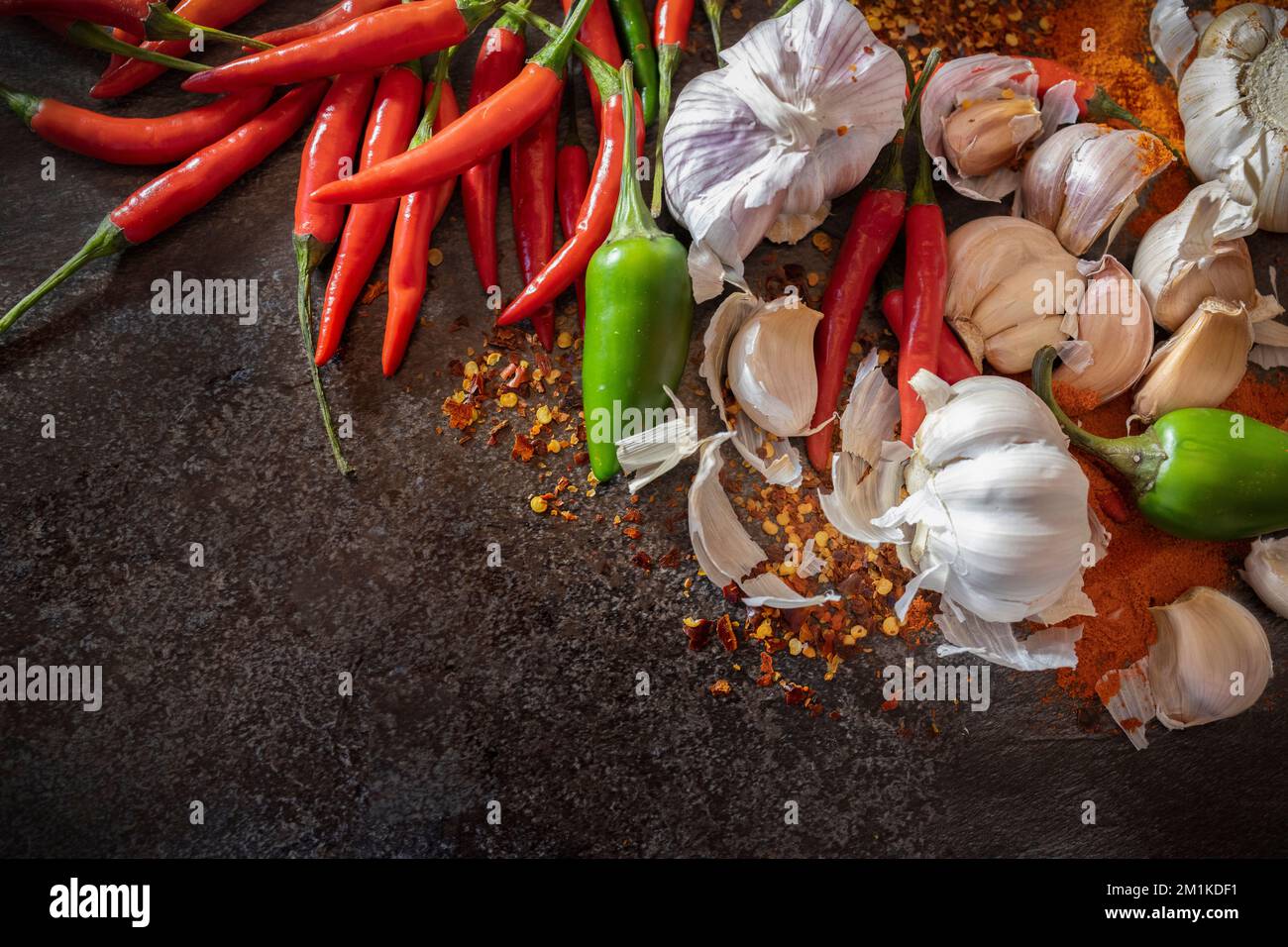 Fresh chilli, peppers and garlic along with dried chilli on a kitchen ...