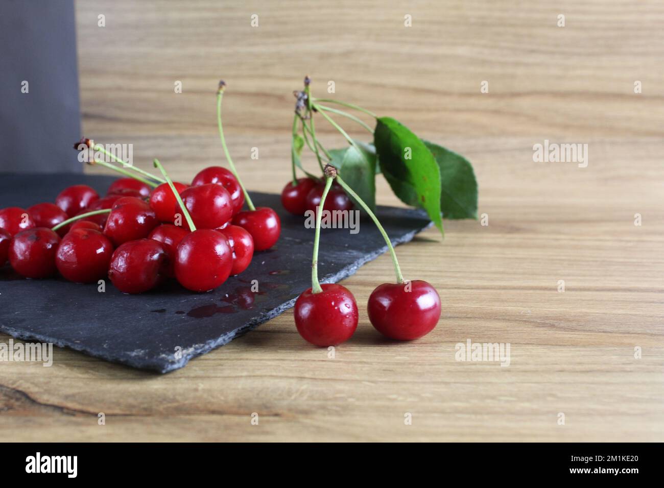 cherries on a black tray on the table. Ripe berry close-up. Growing ...