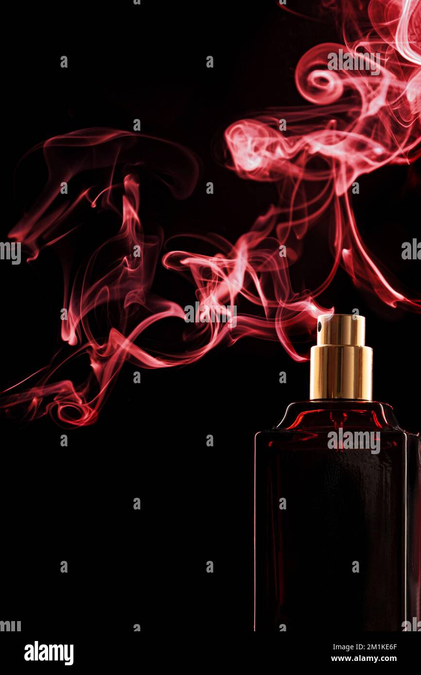 Perfume bottle on a red background with red smoke Stock Photo - Alamy
