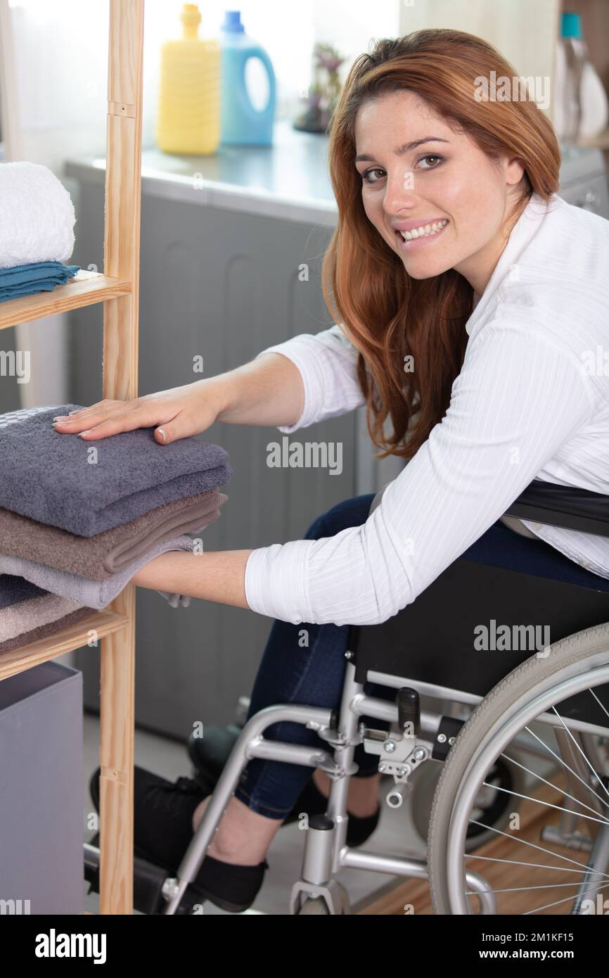 young disabled woman on wheelchair tidying up clean laundry Stock Photo - Alamy
