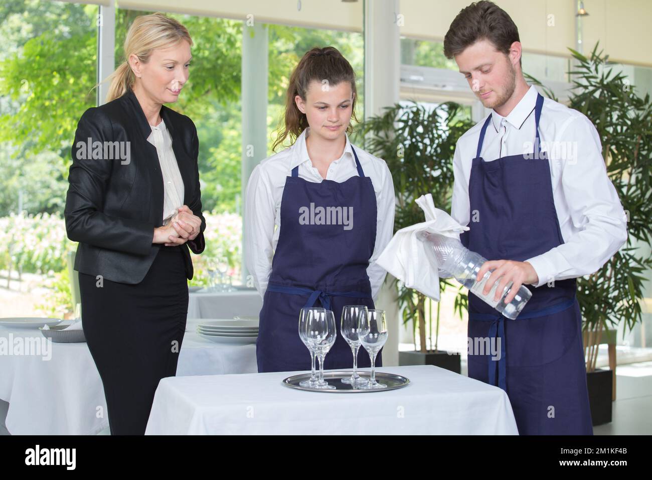 team of waiters standing in apron in restaurant Stock Photo - Alamy