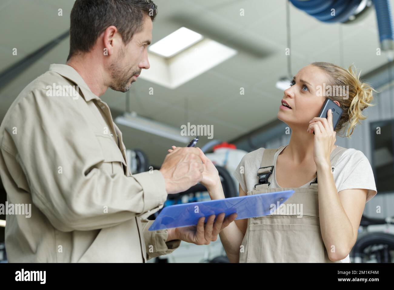 warehouse workers talking on the phone holding clipboard Stock Photo ...