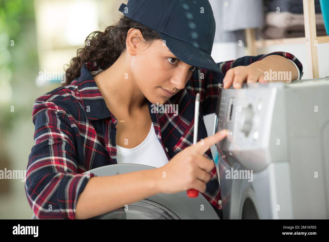 female technician repairing washing machine Stock Photo - Alamy