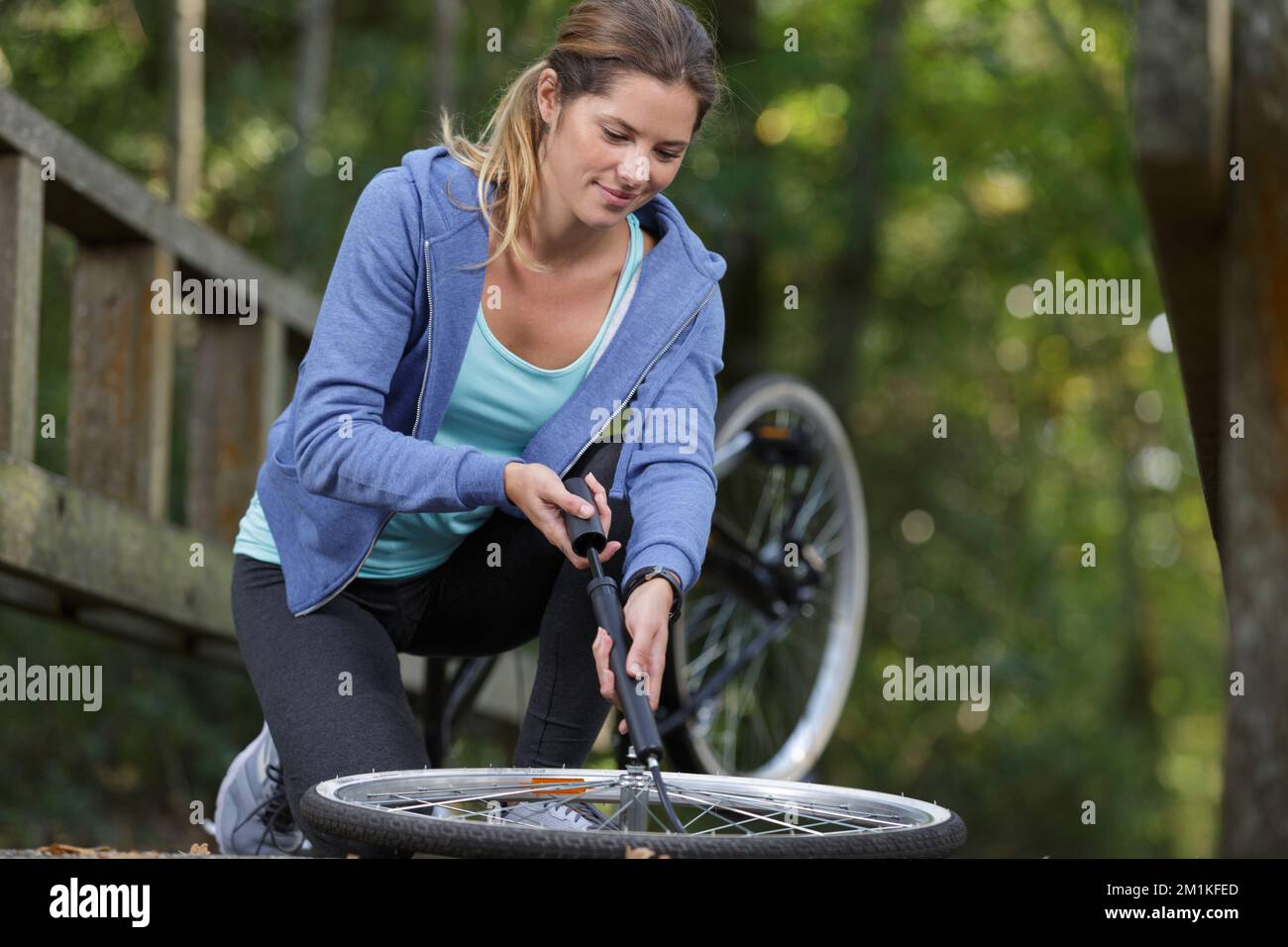 positive woman pumping up a bike tire Stock Photo - Alamy