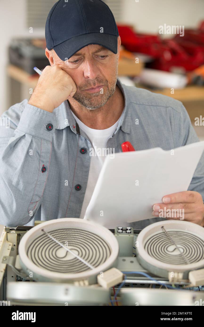 senior man reading instruction for assembling an electrical product ...