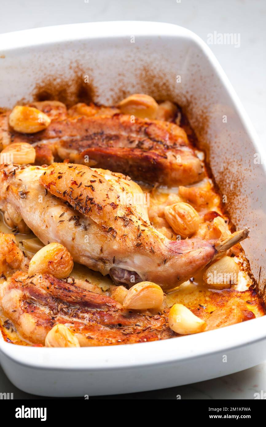 baked rabbit leg with garlic and bacon Stock Photo - Alamy