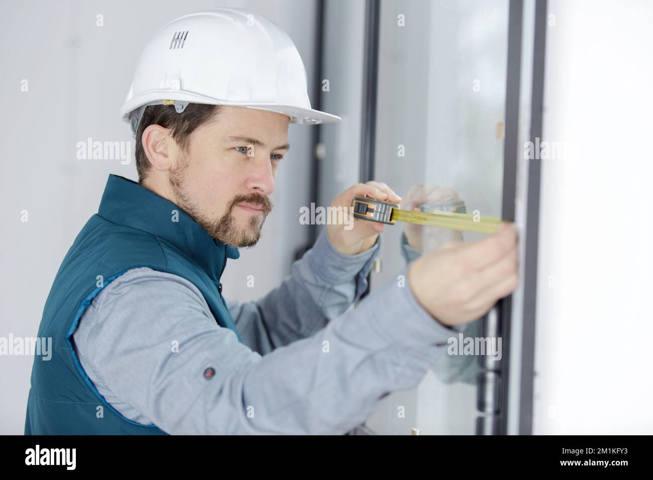 service man measuring window for installation indoors Stock Photo - Alamy