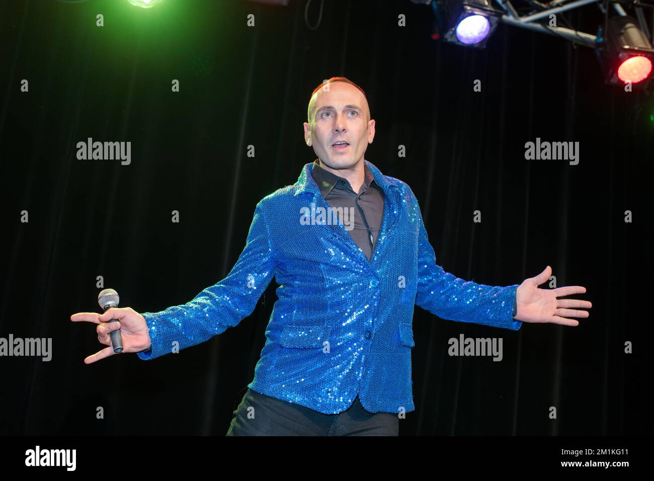 male performer holding a microphone Stock Photo - Alamy