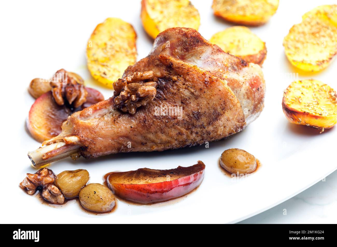 poultry leg baked with fruit and walnuts served with fried potatoes ...