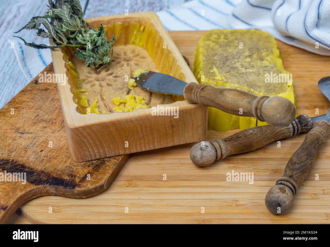 Marijuana butter with wooden mould on blue old table with checker color ...