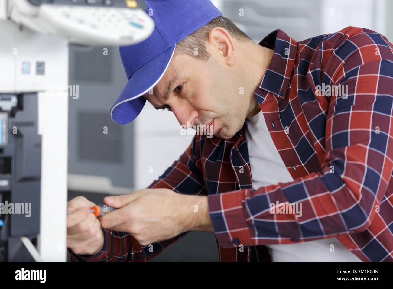 a concentrated man fixing a printer Stock Photo - Alamy