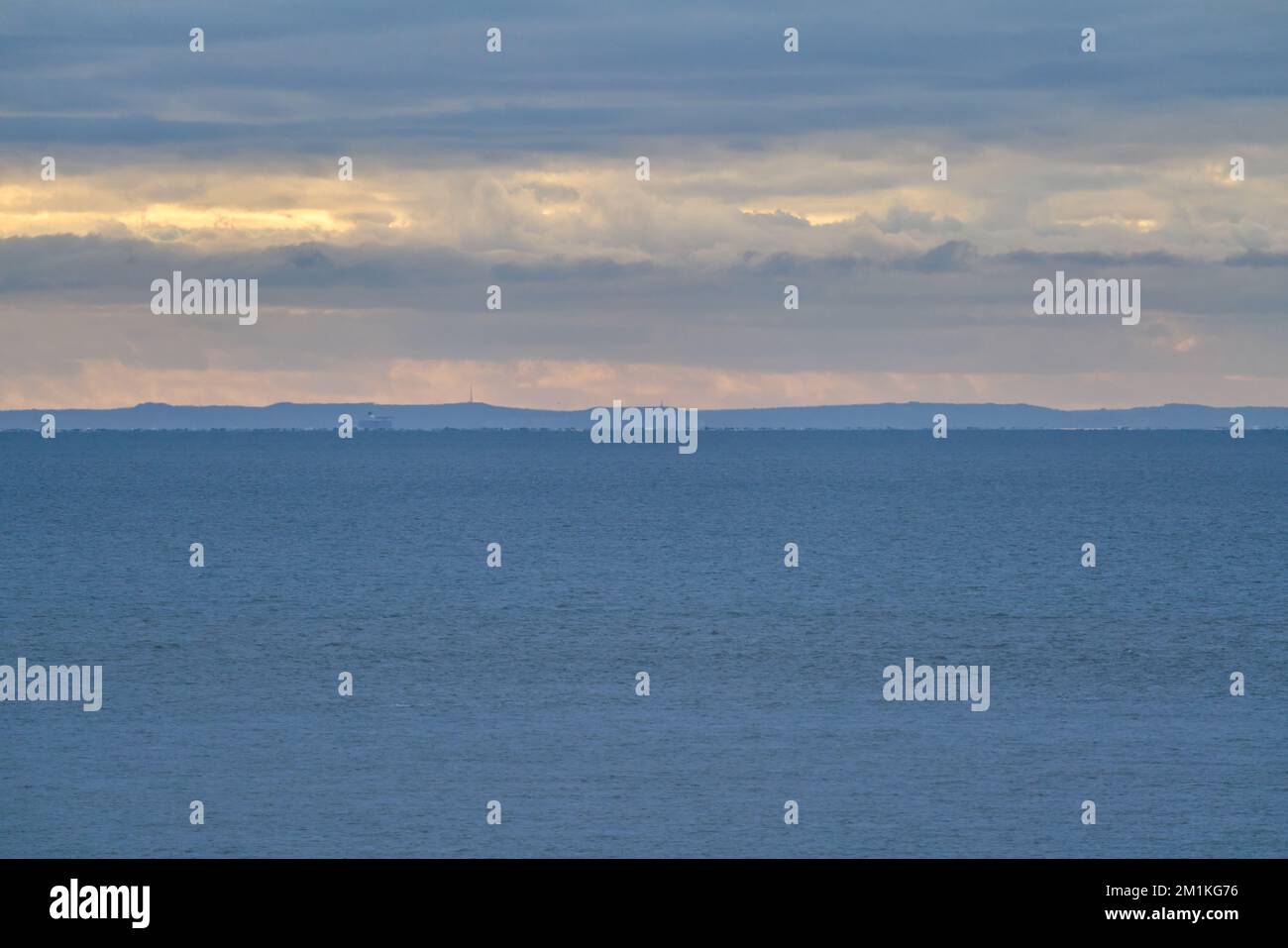 A beautiful bright blue sunset sky over the water near France viewed ...