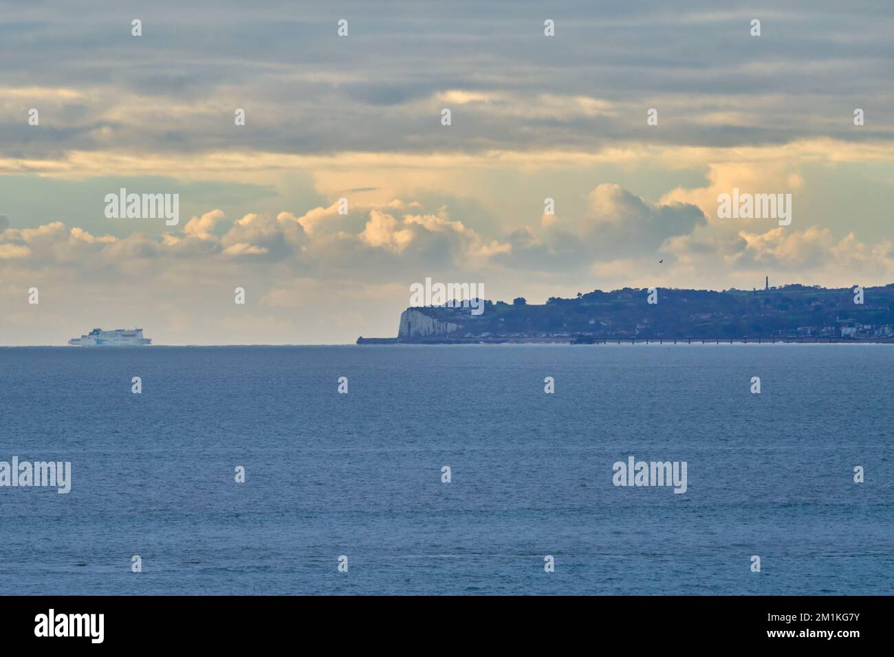 A beautiful bright blue sunset sky over the water near France viewed ...