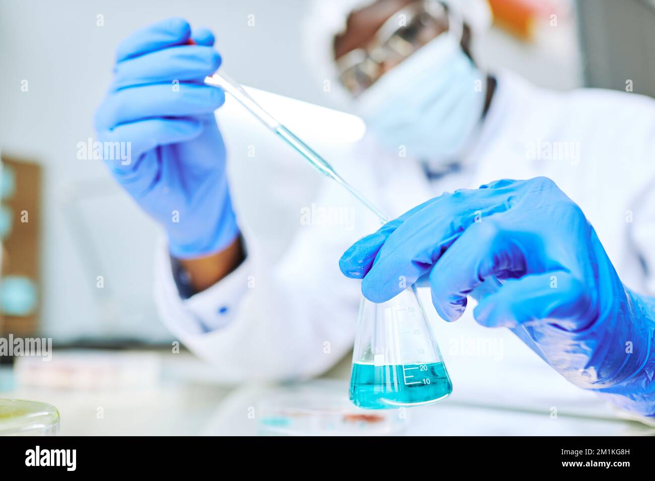 Close up of black scientist taking liquid samples with pipette in ...